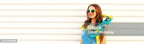 흰색 배경에 녹색 스케이트 보드와 함께 포즈를 취하는 행복한 미소 젊은 여성의 여름 초상화 광고 텍스트를위한 빈 복사 공간 스케이트보드에 대한 스톡 사진 및 기타 이미지