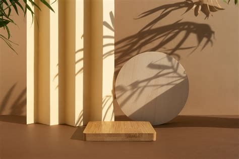 추상적인 베이지색과 갈색 배경에 야자수 잎의 그림자가 있는 나무 연단 기하학적 배경이 있는 장면입니다 제품 프레젠테이션의 배경입니다 빈 쇼케이스 베이지에 대한 스톡 사진 및