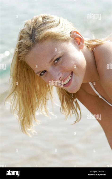 Female With Long Blonde Hair Wearing White Bikini Top Bending Over