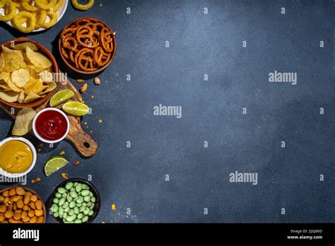 Various Unhealthy Salty Bar Snacks Set Dark Grey Table Background With Traditional Party Snacks