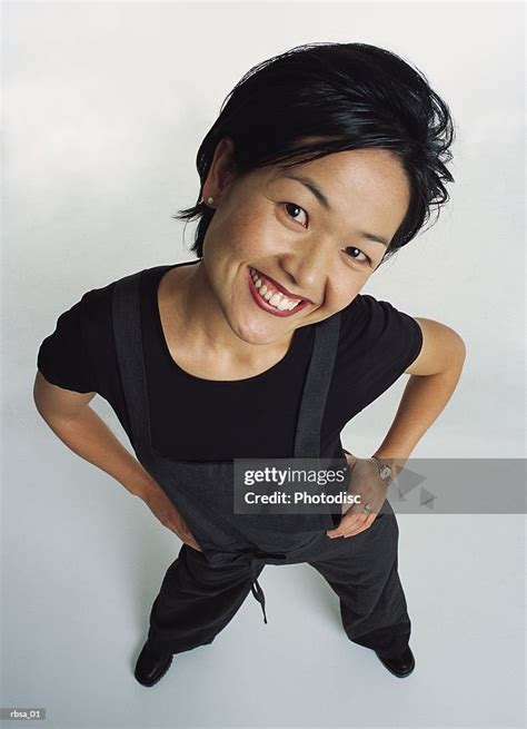 Young Cute Perky Asian Female Adult Wearing A Dark Jumper Looks Up At