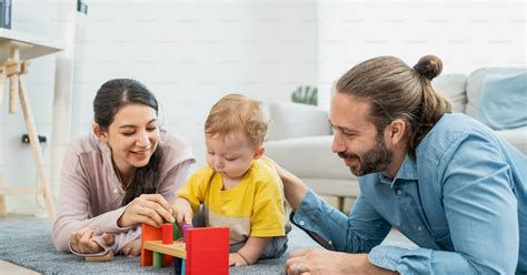 백인 행복 하 고 사랑하는 부모는 거실에서 아기 유아와 놀고 있습니다 어린 어린 유아 아들 아이의 발달을 바라보는 매력적인 부부 어머니와 아버지 집에서 집에서 활동 관계