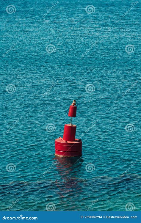 Big Red Iron Navigational Buoy With Signaling Light Floating On Sea