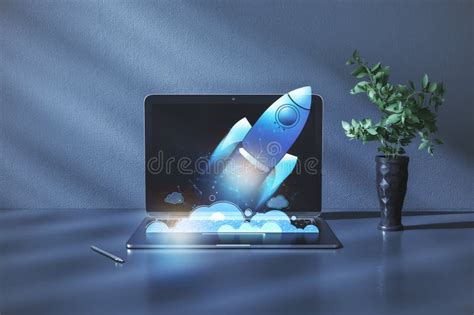 Close Up Of Laptop Computer At Workplace With Supplies And Glowing Flying Blue Rocket Start Up
