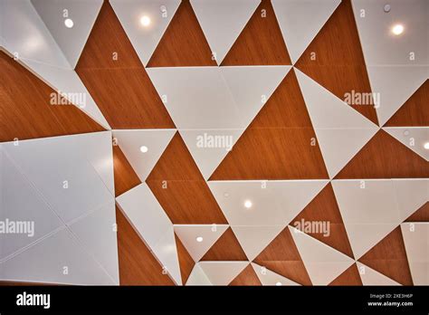geometric ceiling design with triangular panels and recessed lighting