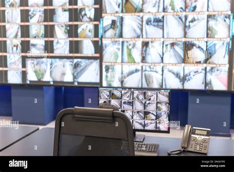 Security Officer Monitoring Multiple Surveillance Screens In A High Tech Control Room For Safety
