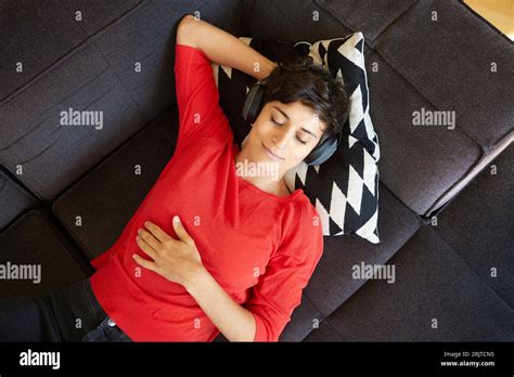 unwinding in style this woman indulges in music while lounging on the