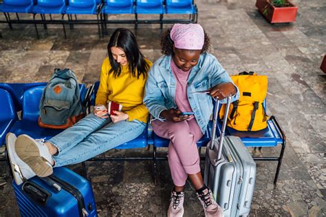 휴대 전화를 사용하고 기차역에서 기차를 기다리는 친구들 2명에 대한 스톡 사진 및 기타 이미지 2명 고독 개념 공항