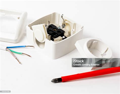 흰색 테이블에는 설치할 준비가 된 분해된 전기 콘센트 제거된 전선 및 전기 기술자를 위한 빨간색 드라이버가 있습니다 전기 설치 수리 0명에 대한 스톡 사진 및 기타 이미지