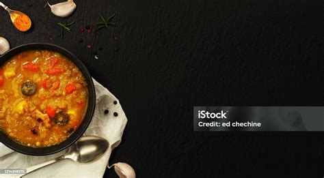 고기 당근 파프리카 심황을 곁들인 전통적인 완두콩 수프 검은 돌 배경에 수프 마늘의 정향 옆에 로즈마리와 심황의 잔가지 플랫