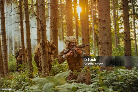 현대전 군인 그룹이 위험한 외딴 산림 지역에서 전쟁을 벌이고 있습니다 한 무리의 군인들이 현대 무기로 적진에서 싸우고 있습니다 전쟁과 군사 분쟁의 개념 걷기에 대한 스톡