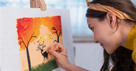 아시아의 젊은 재능 있는 여성 예술가가 집에서 그림 보드에 색칠하고 있다 매력적인 아름다운 여성은 수채화 물감과 브러시로 예술 작품을 만들고 집에서 창의력 활동을 즐깁니다