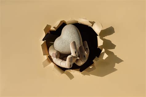 찢어진 베이지 색 종이에 종이 구멍을 통해 나무 모델 손에 골판지 심장 최소한의 트렌디 한 감사 카드 Giving Tuesday