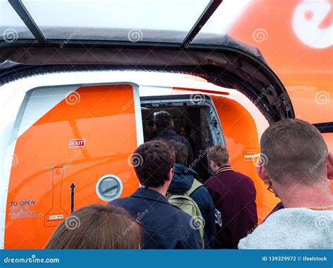Group Of Passengers Standing In Front Of Doors Of The Passenger Train