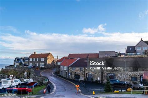 석조 주택과 맑고 푸른 하늘이 있는 고풍스러운 유럽 마을에는 눈에 잘 띄는 옷을 입은 노동자와 육지 위의 보트가 있습니다 0명에 대한 스톡 사진 및 기타 이미지 Istock