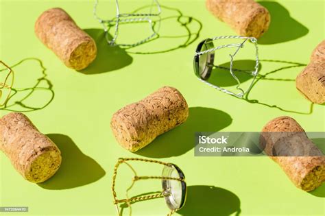 그림자가 있는 녹색 햇볕이 잘 드는 배경에 샴페인 코르크로 만든 창의적인 구성 스파클링 와인과 금속 와이어 뮤즐렛으로 만든 병 뚜껑 여름 파티 음료 컨셉 0명에 대한 스톡