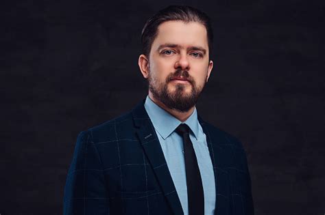 수염과 헤어스타일와 잘생긴 중 년 남자의 클로 우즈 업 초상화 우아한 정장 양복 입고 스튜디오에서 질감 어두운 배경에 고립