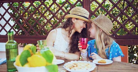 크로스타타 녹색 물병 현지 농장 레몬 접시가 파티오에서 점심을 먹고 있는 테이블에 앉아 있는 행복한 트렌디한 엄마와 딸