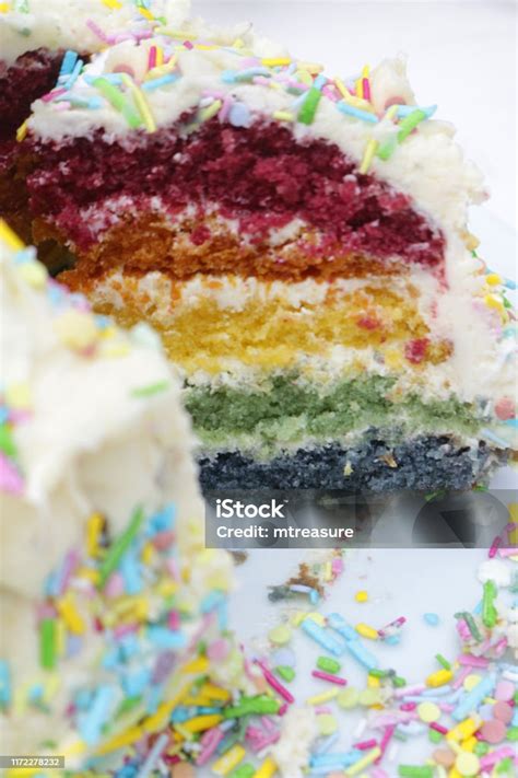 화이트 버터 크림 질감의 아이싱과 색종이 슈가 페이스트 를 여러 가지 색상의 파스텔 색조로 덮인 생일 케이크에서 가져온 집에서 만든 무지개 층 스폰지 조각의 이미지 0명에