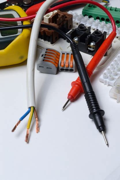 Premium Photo Stripped Three Core Wire Terminal Block And Multimeter Probes Light Background