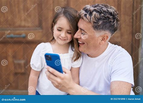 Padre E Hija Sonriendo Confiados Usando El Smartphone En Park Foto De