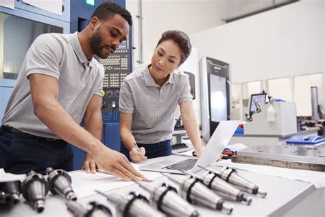 two engineers using cad programming software on laptop stock image