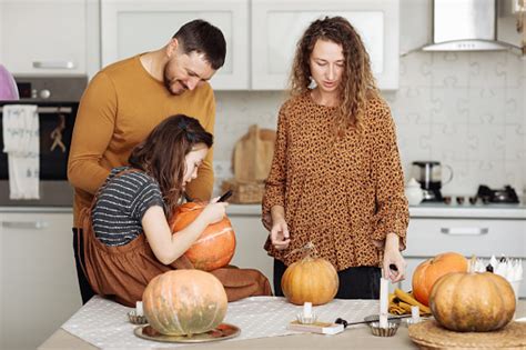 행복한 가족 어머니 아버지와 자녀 딸은 할로윈을 준비하고 호박으로 집을 장식하고 잭을 만들고 웃고 놀 수 있습니다 선택적 초점 부엌에 대한 스톡 사진 및 기타 이미지