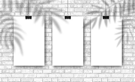 흰색 벽돌 벽 배경과 손바닥 그림자 오버레이에 세 개의 빈 흰색 수직 포스터가있는 벡터 모형 트렌디 한 포트폴리오 블랑 공간 프레임 배경 웹 포트폴리오 포스터 모형 광고