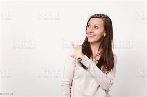 밝은 옷을 보고 웃는 젊은 여자의 초상화 스튜디오에서 흰색 벽 배경에 고립 된 인덱스 손가락을 가리키는 사람들은 진심으로 감정 라이프 스타일 개념입니다 복사 공간을 모의