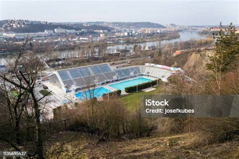 실내 및 실외 수영장이 있는 가장 큰 수영 단지 백그라운드에서 블타바 강이 있는 토 보건 워터 슬라이드 및 다이빙 타워 포 돌리 프라하 체코 강에 대한 스톡 사진 및 기타