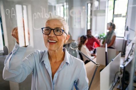 mature female coach making notes of information during workflow