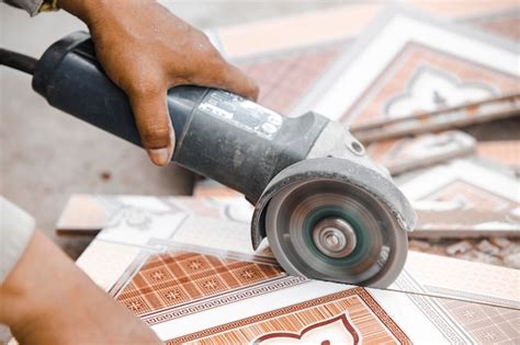 Premium Photo Worker Cutting A Tile Using An Angle Grinder At