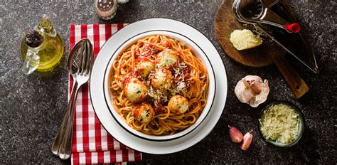 토마토 소스의 리 코타 치즈 볼을 곁들인 이탈리안 파스타 스파게티의 깃발 파마산 치즈와 함께 식탁에 온 가족 파티 또는 레스토랑 메뉴를 위한 건강 한 전통 이탈리아 음식