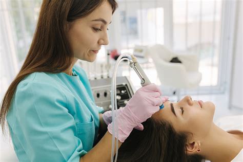 얼굴 하이드로 미세 피부 마모 필링 치료를 받고 여자의 클로즈업 화장품 뷰티 스파 에서 여성 Slinic 히드라 진공 청소기 미용 술 Electrolysis에 대한 스톡