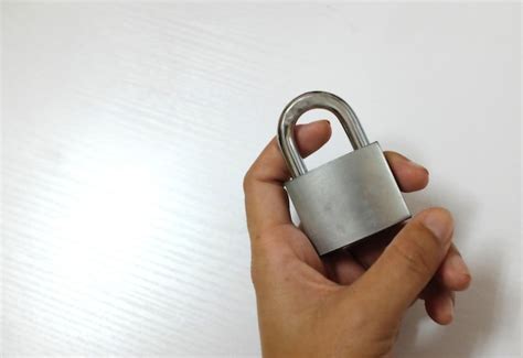 Premium Photo Cropped Hand Of Person Holding Padlock On Table