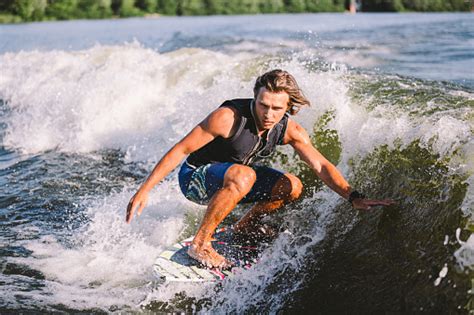 아름다운 긴 머리 금발 웨이크 서핑 호수의 파도를 따라 보드에 조끼 육상 남성 선수는 강에서 여름에 서핑을 깨워 웨이크 서핑 수상 스포츠 파도에 서퍼 서핑보드에서 서핑하는