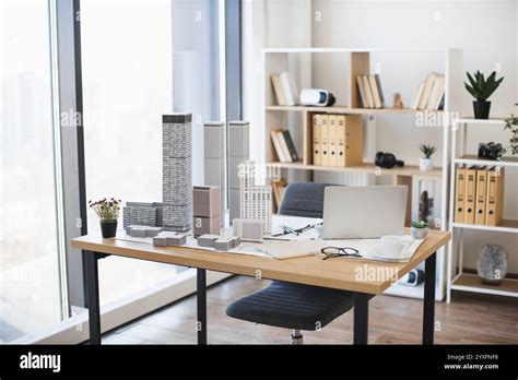 Modern Office Desk Features Architectural Model And Laptop Setup Bright Workspace Includes