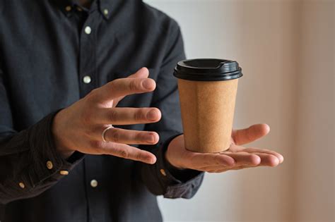 남자는 커피 나 차와 함께 손 종이 컵에 들고 사업가가 커피를 마십니다 순간을 즐기고 휴식을 취하십시오 커피가서 일회용 종이 컵