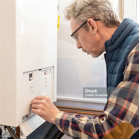 백인 50 세 남성은 에너지 위기로 인해 집안의 가스 보일러 온도를 낮 춥니 다 보일러에 대한 스톡 사진 및 기타 이미지 보일러 50 54세 가격 Istock
