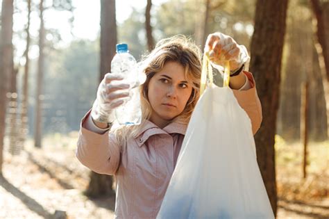 슬프고 실망한 여성 자원 봉사자 및 조수는 플라스틱 쓰레기 쓰레기로부터 숲을 청소합니다 쓰레기 봉투와 병 표시 25 29세에 대한 스톡 사진 및 기타 이미지 Istock