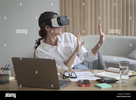 happy woman exploring augmented world at work touching 3d virtual
