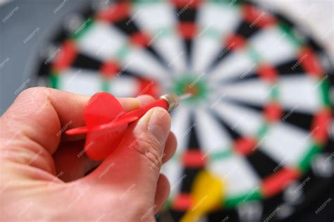 premium photo a hand throws darts on a dartboard a hand holding a