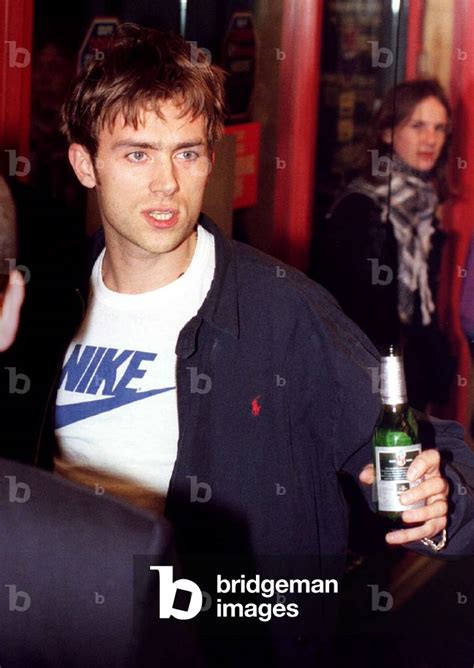 Image Of Lead Singer Of Blur Damon Alburn Carries A Bottle Of