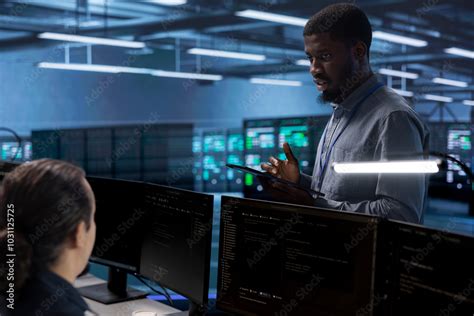 african american man in data center using diagnostic tools and system