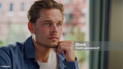 잘 생긴 남자의 얼굴 초상화를 닫습니다 창조적 인 남성은 집에 앉아서 데스크톱 컴퓨터에서 일합니다 소셜 미디어 확인 인터넷 검색 로프트 시티 아파트의 거실 모형에 대한 스톡