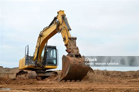 굴삭기는 새로운 건물의 기초와 건설을위한 땅을 파고 도로 수리 아스팔트 교체 고속도로의 섹션을 개조 누워 또는 지하 하수 파이프의 교체 0명에 대한 스톡 사진 및 기타