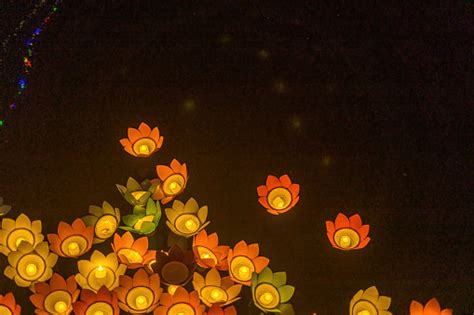 종이와 촛불로 만든 밤에 부처님의 생일을 축하하기 위해 Vesak 낮 날에 밤에 강에 떠 다니는 색색의 등불과 화환 돌아가신