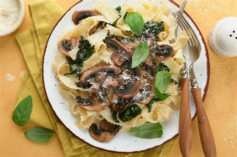 크리미 알프레도 파스타 버섯 닭고기 시금치 바질 크림 소스를 곁들인 이탈리아 파스타 페투치니가 노란 돌이나 콘크리트 배경에 있습니다 전통적인 이탈리아 요리 플랫 레이 복사