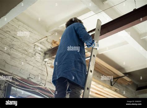 Guy Is Standing On Stairs Worker Hangs Chain On Steel Beam Construction Staircase Man Stands