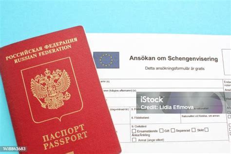 Schengen Visa Application Form In Swedish Language And Passport On Blue